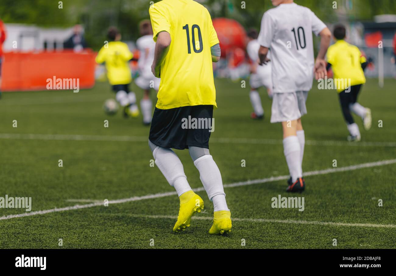 Back of junior football player playing game on the sports stadium ...
