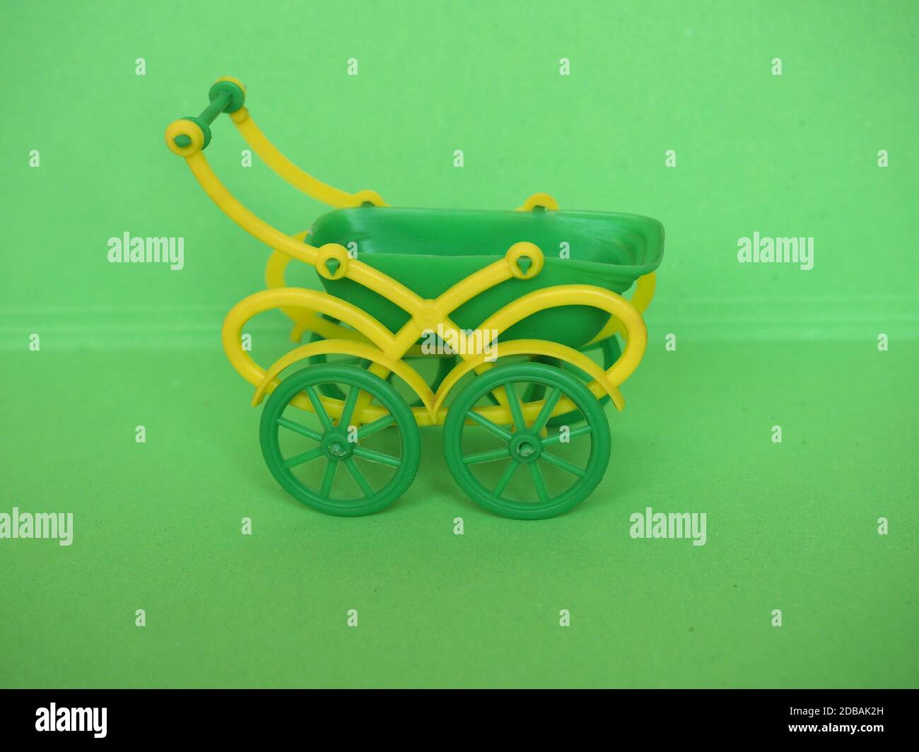 empty green plastic toy baby pushchair (aka stroller Stock Photo - Alamy