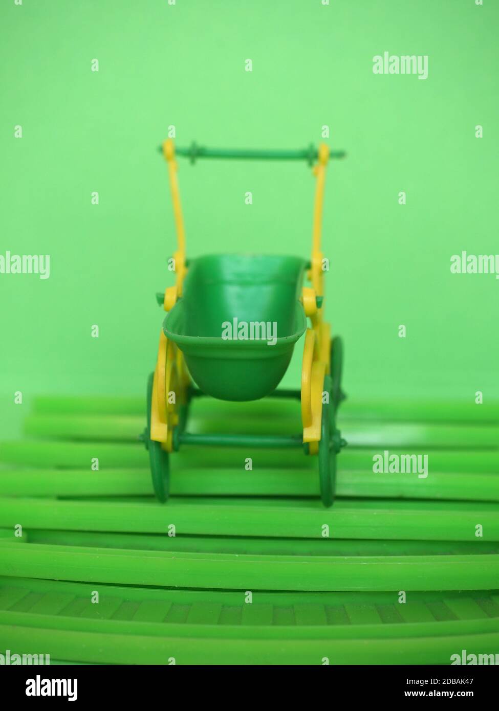 empty green plastic toy baby pushchair (aka stroller Stock Photo - Alamy