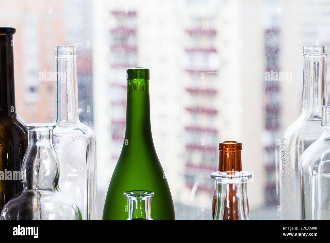 many empty bottles and view of apartment buildings through home window ...