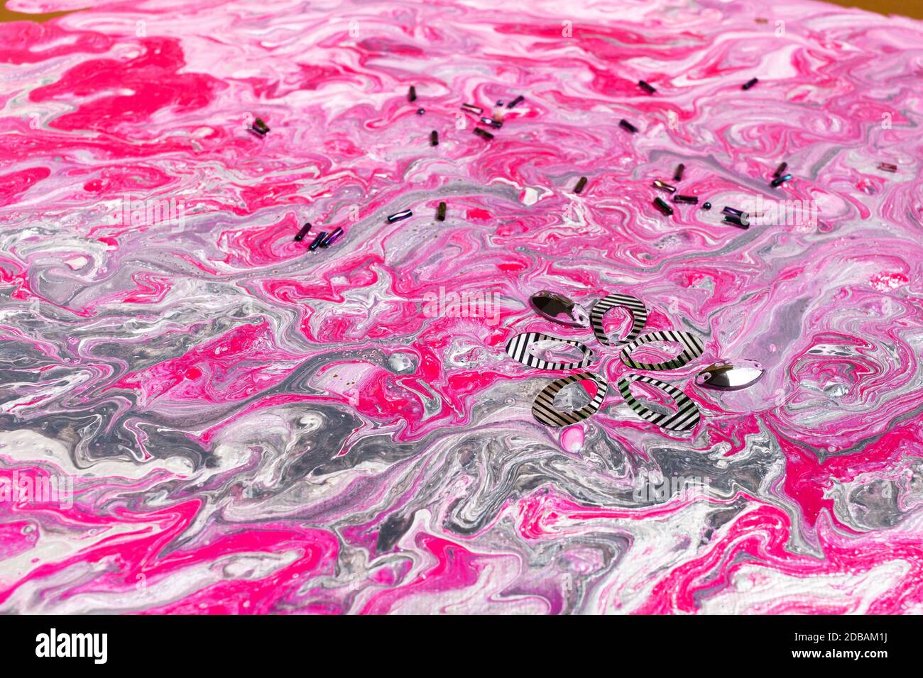 surface of abstract painting with flowing pink and silver acrylic ...
