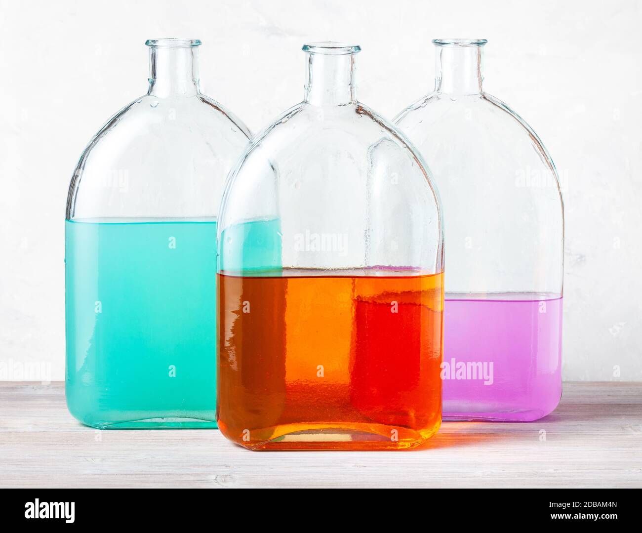 glass flasks with color watercolour solutions on gray wooden board near ...