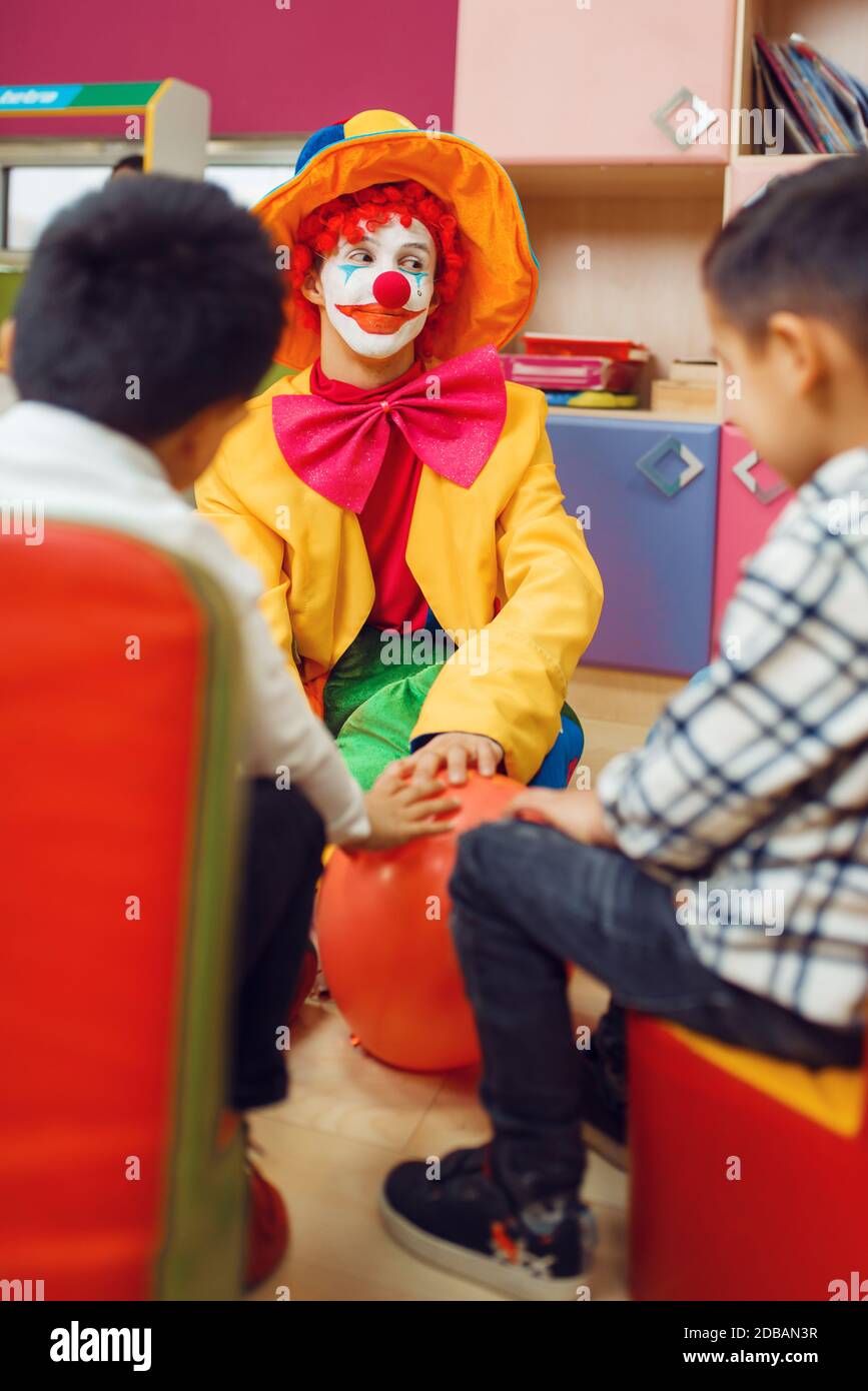 Funny clown play with cheerful children together. Birthday party ...