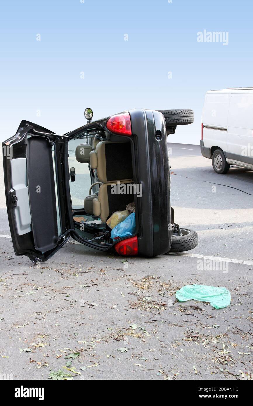 Traffic accident black car roll over side Stock Photo - Alamy