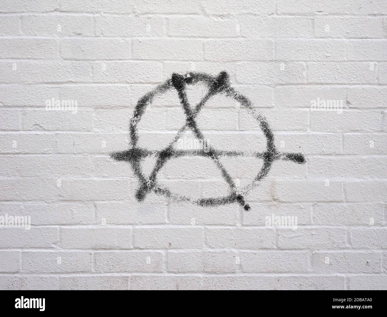 Circle A symbol of anarchy and anarchism spray painted on white brick ...
