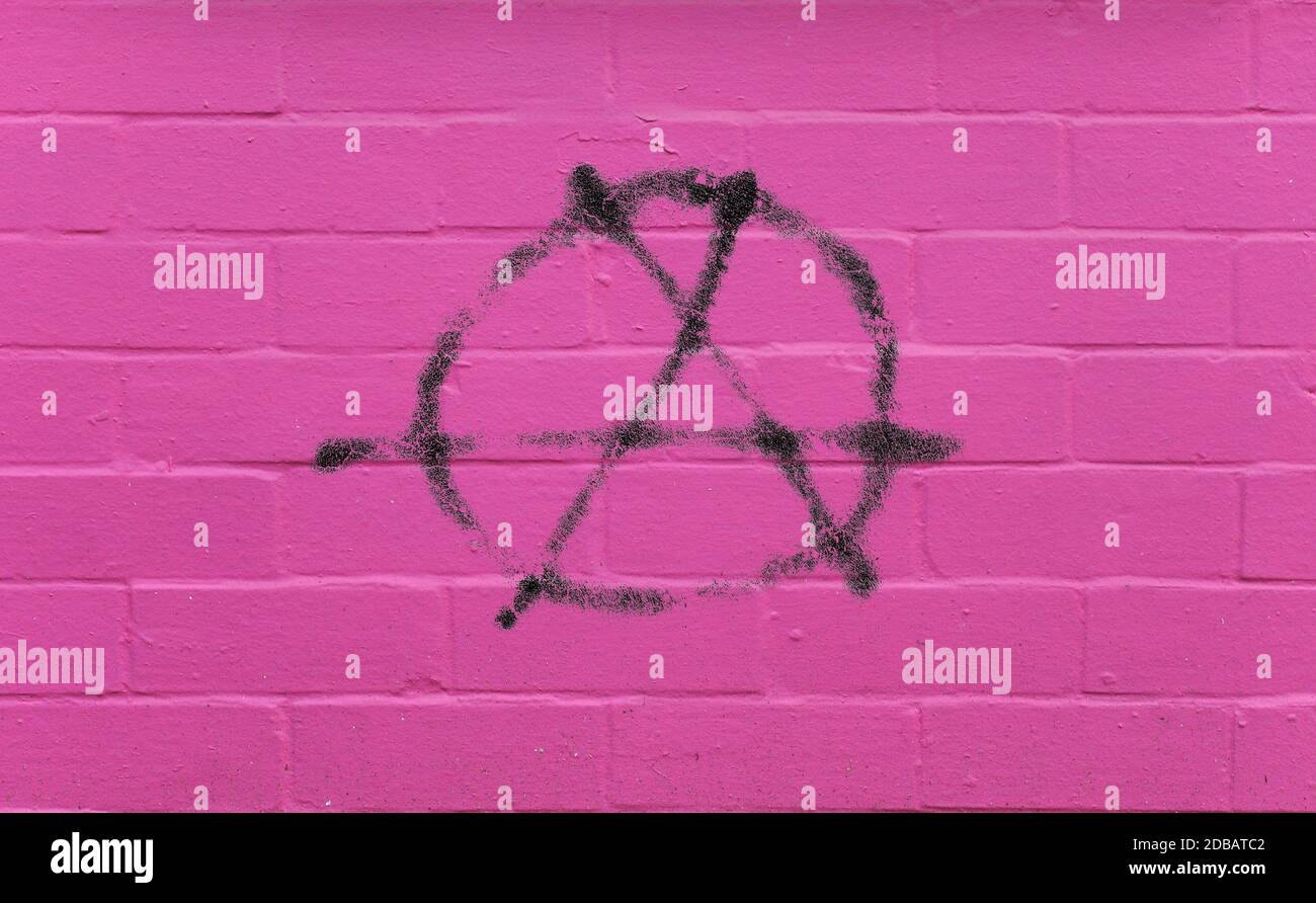 Circle A symbol of anarchy and anarchism spray painted on pink brick ...