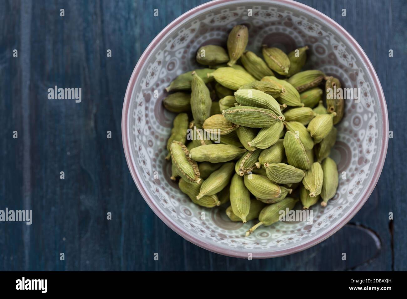 Green cardamom whole seeds in vintage bowl on wooden background Stock ...