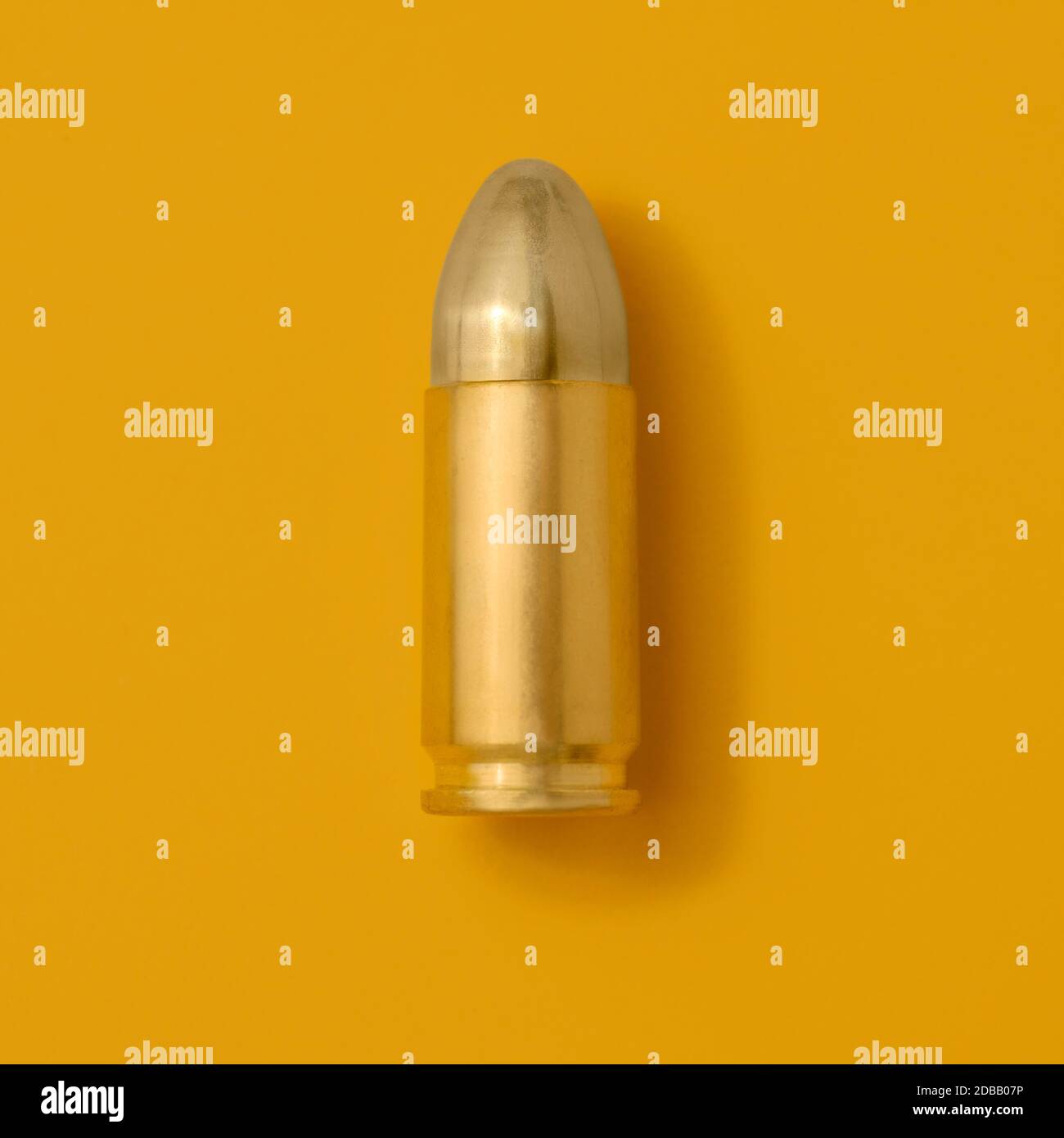 Gold bullet on yellow background Stock Photo - Alamy
