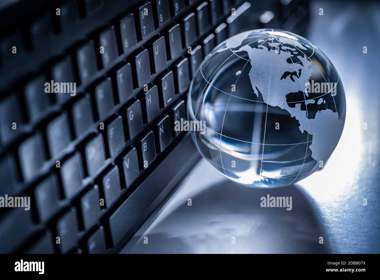 Glass globe and computer keyboard on gray background Stock Photo - Alamy