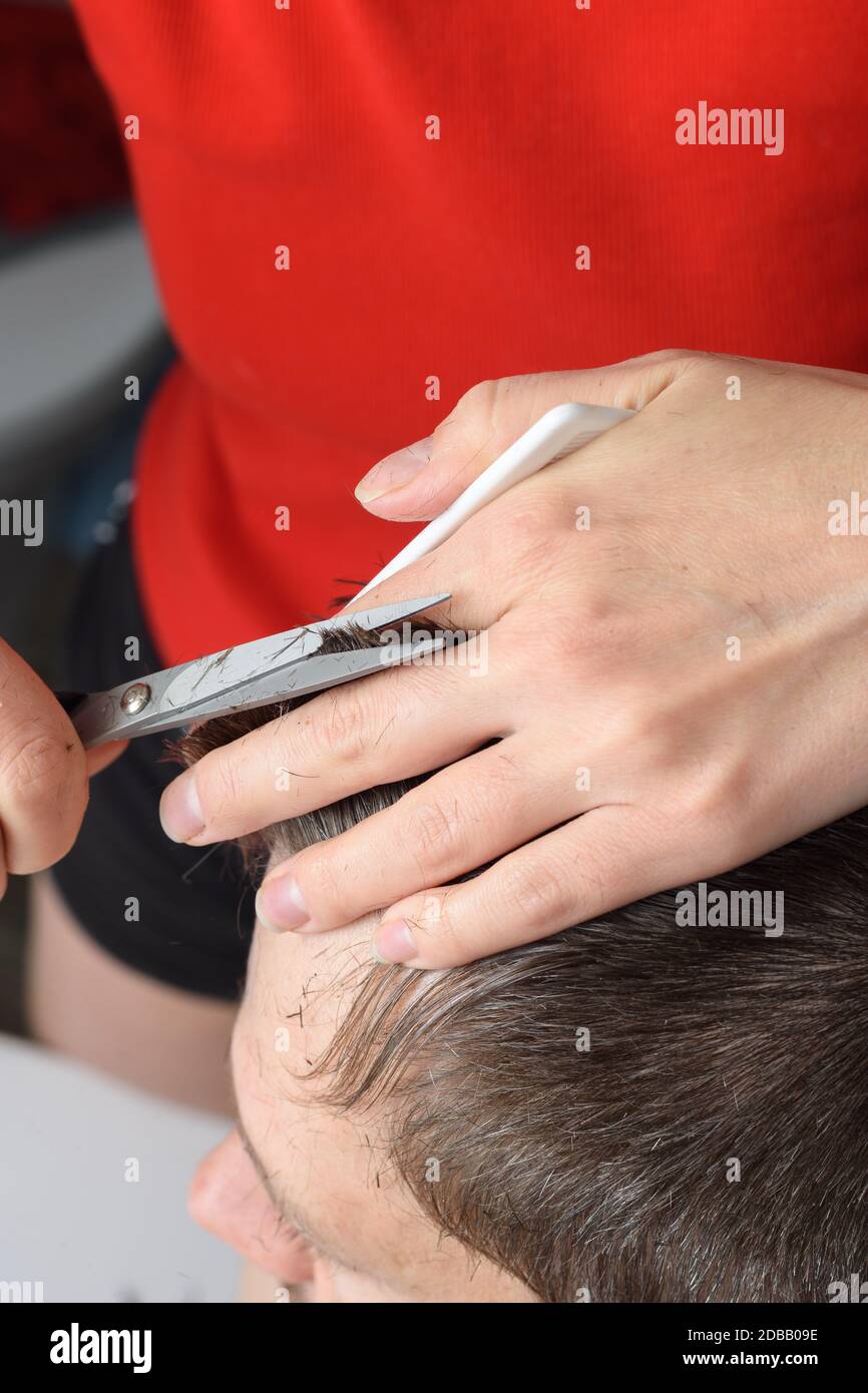 Wife cuts hair on husband's head at home in the bathroom Stock Photo ...