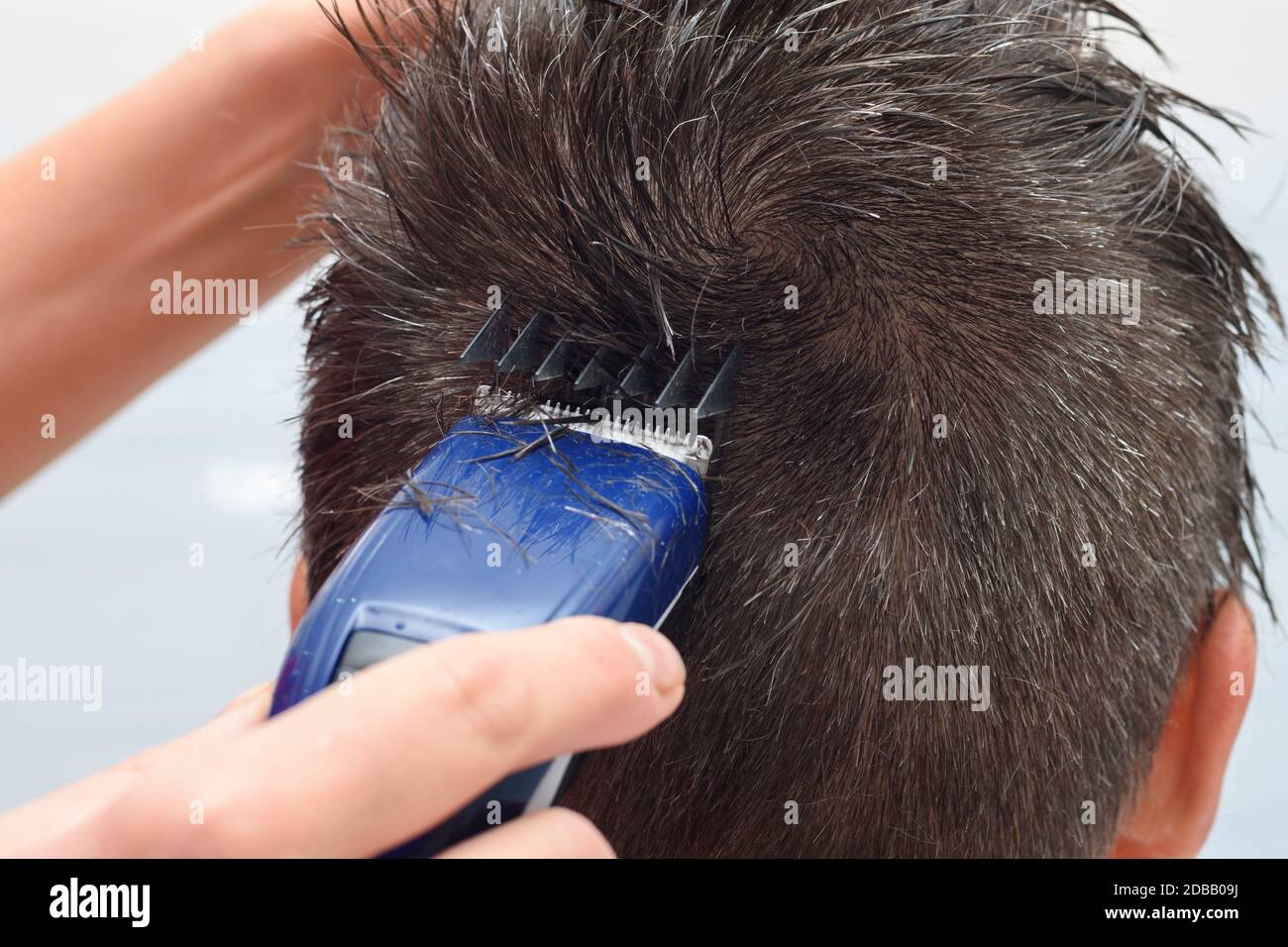 Hairdresser cuts the hair on the top of the head, close-up Stock Photo ...