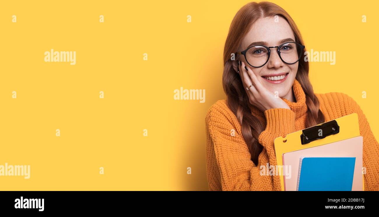 Monochrome photo of a ginger student with freckles smiling on a yellow ...
