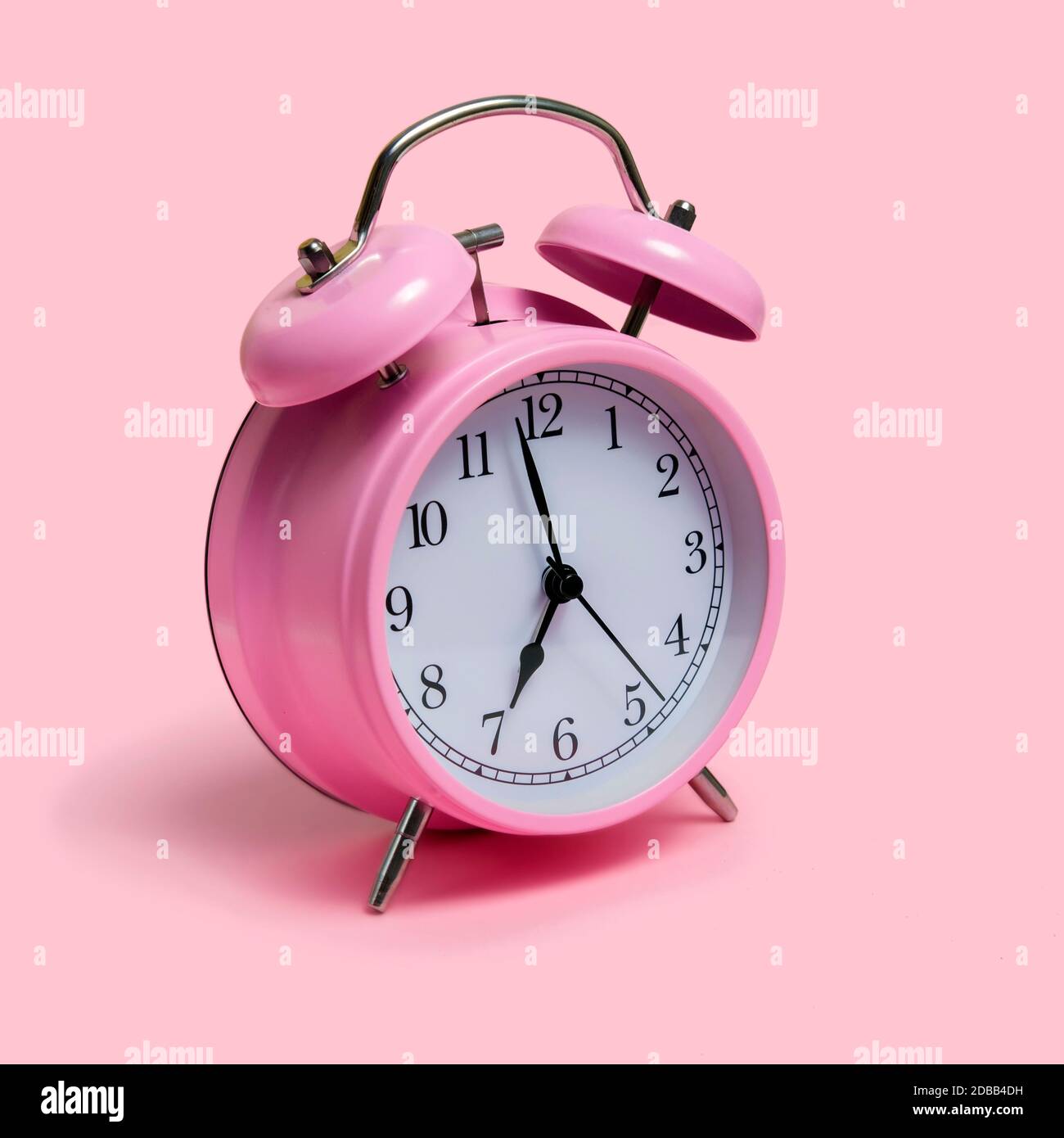Alarm clock on pink background Stock Photo - Alamy