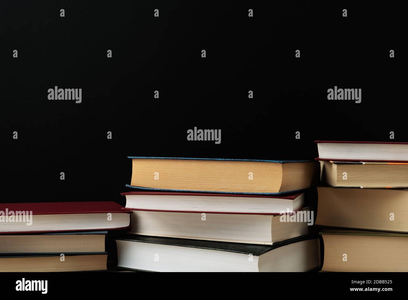 Stacks of books several on a black background close-up. Hardcover books ...