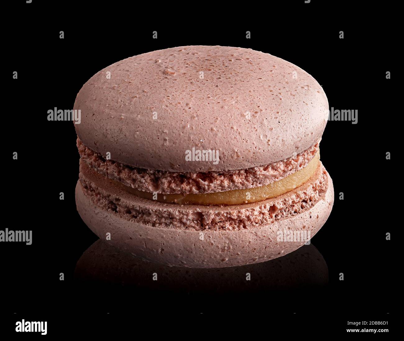One beige macaroon angled view on black background Stock Photo - Alamy