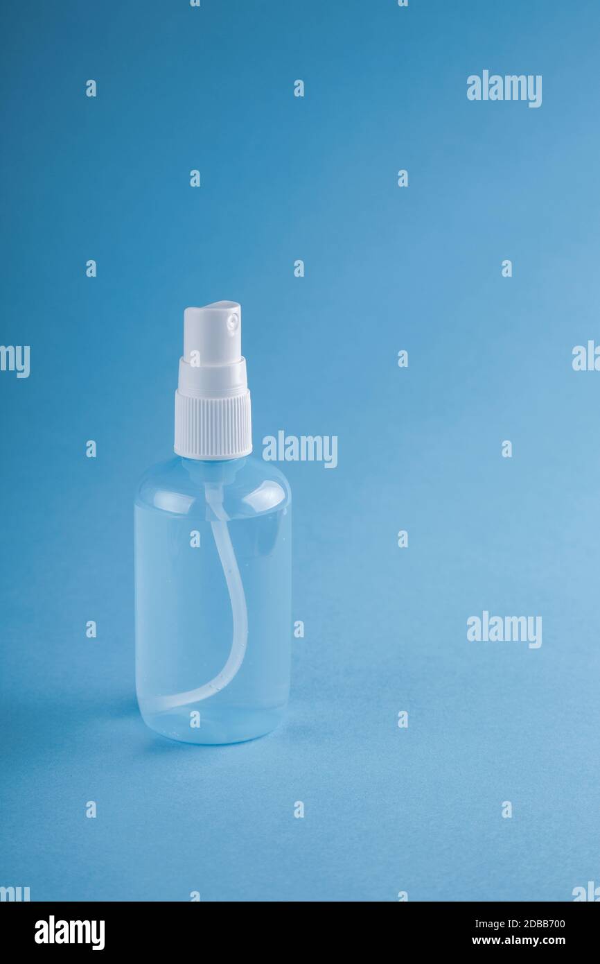 Bottle of antiseptic gel isolated on blue. Antibacterial spray for ...