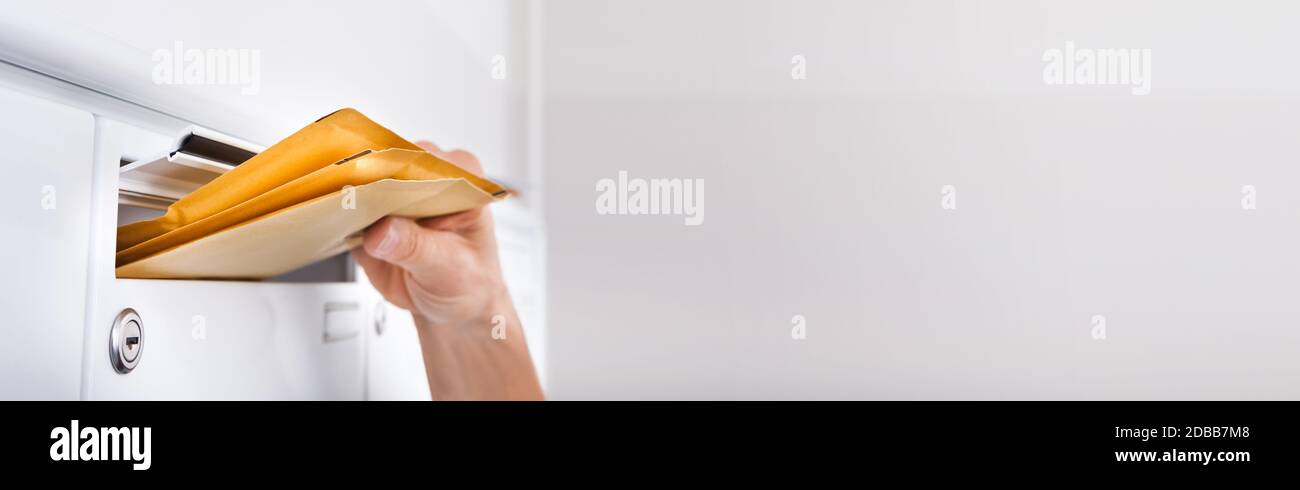 Postman Putting Mail In Mailbox. Postal Service Man Stock Photo - Alamy