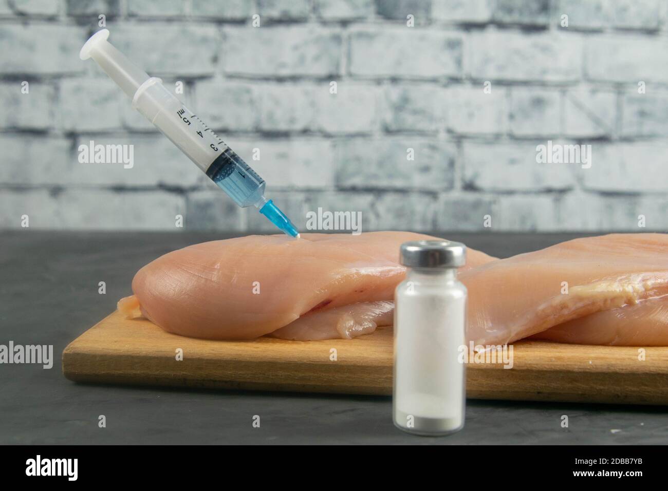 Injection syringe in raw chicken pieces, concept of injection of GMOs ...