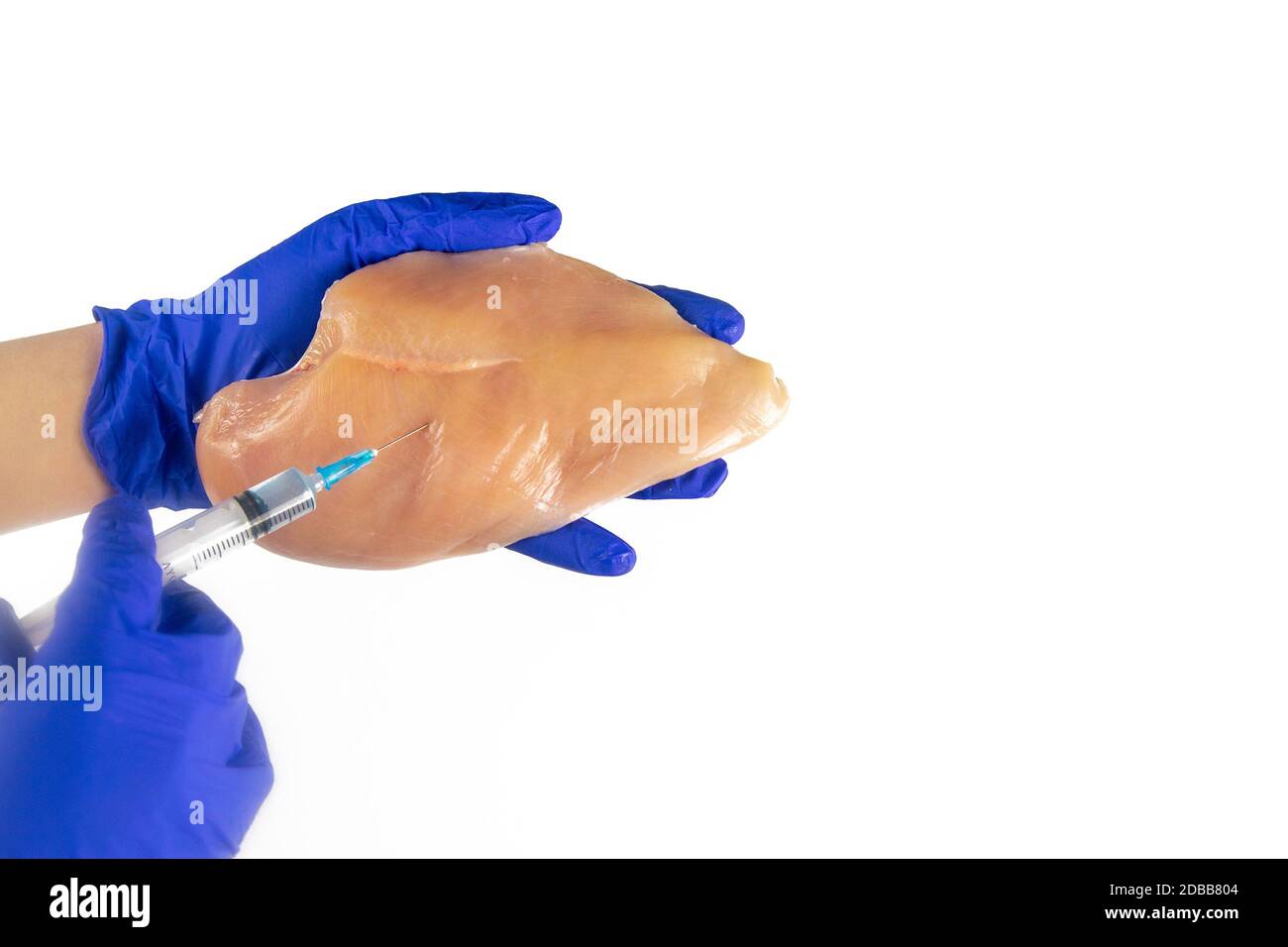 People make injection syringe in chicken fillet on white background ...