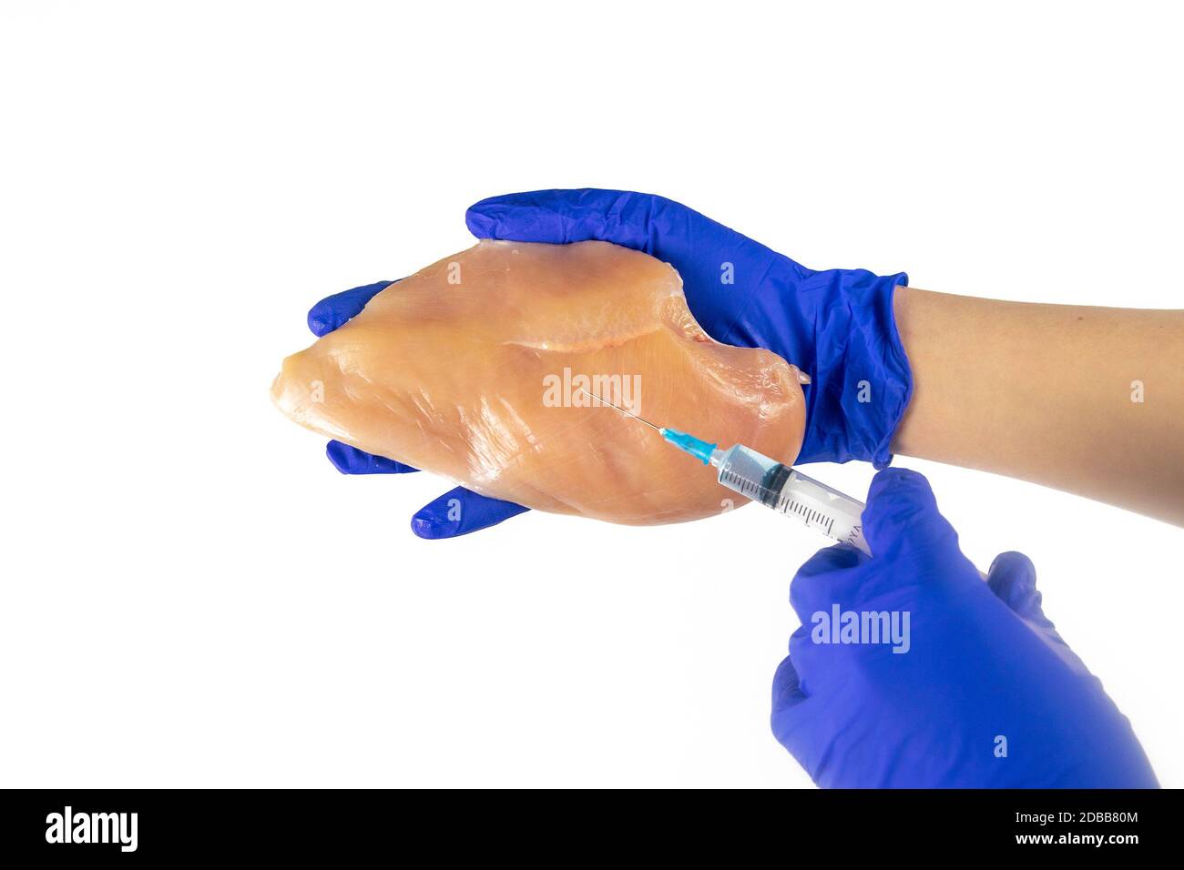 People make injection syringe in chicken fillet on white background ...