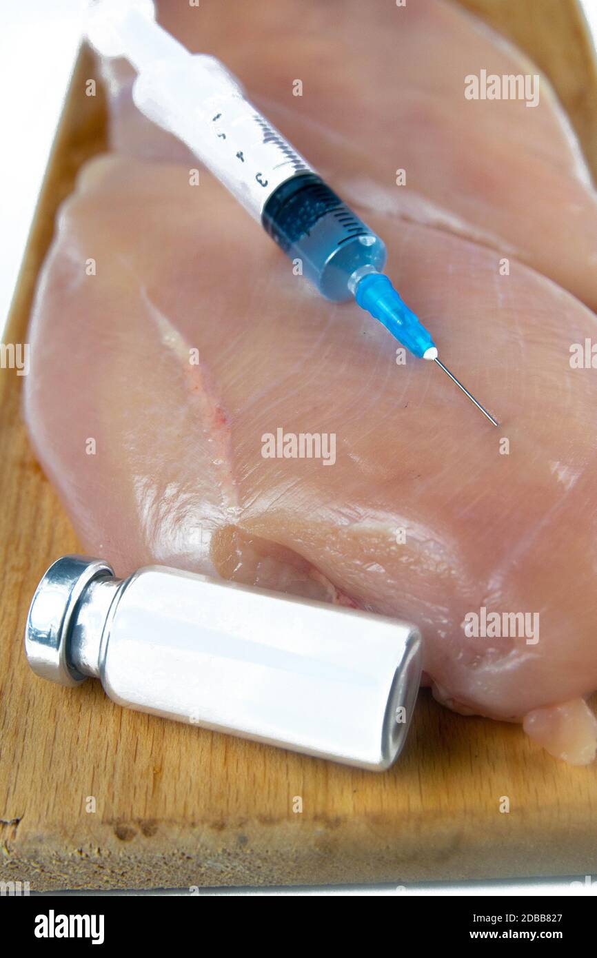 Syringe with liquid being injected to a piece of meat. Conceptual ...