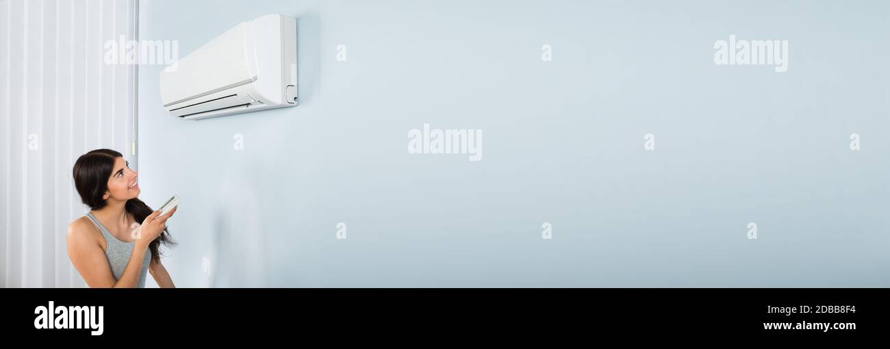 Woman using air conditioner hi-res stock photography and images - Alamy