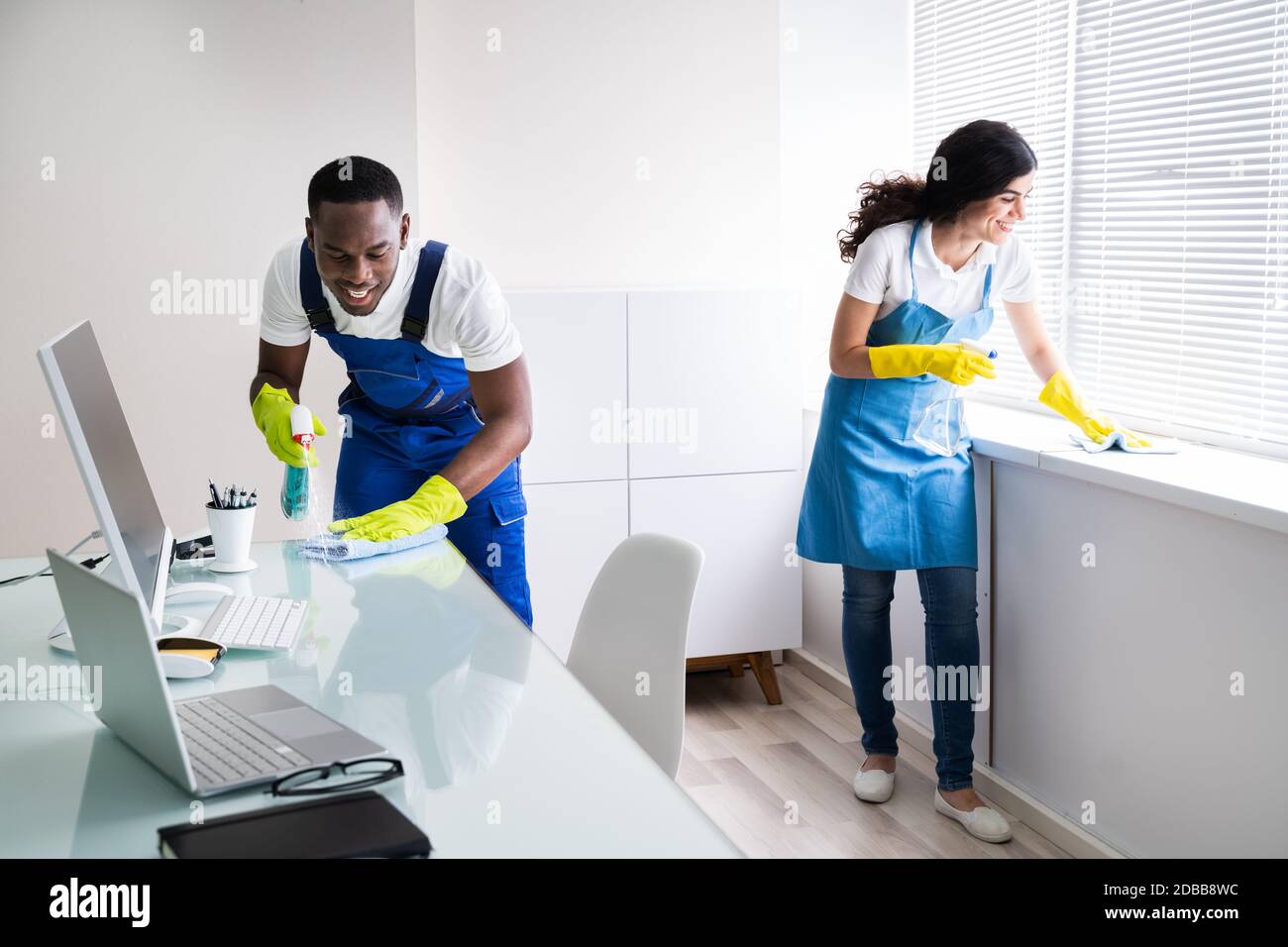 Young Male And Female Cleaners Cleaning Office Stock Photo - Alamy