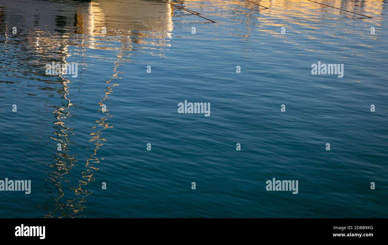 Reflections of boats in the harbor on sea water Stock Photo - Alamy
