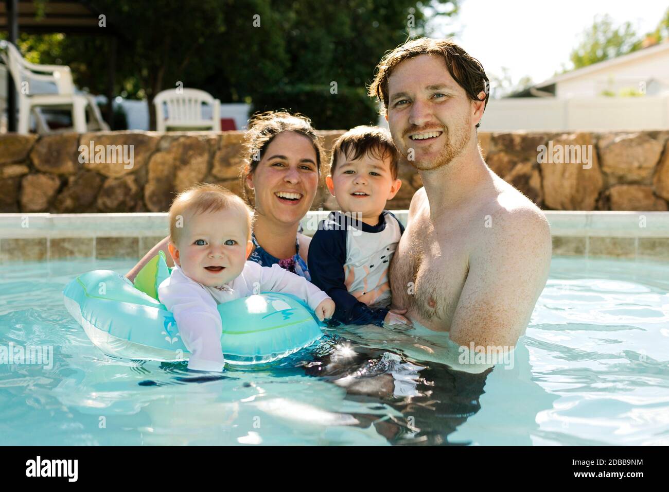Portrait of parents with kids (2-3, 6-11 months ) standing in outdoor ...