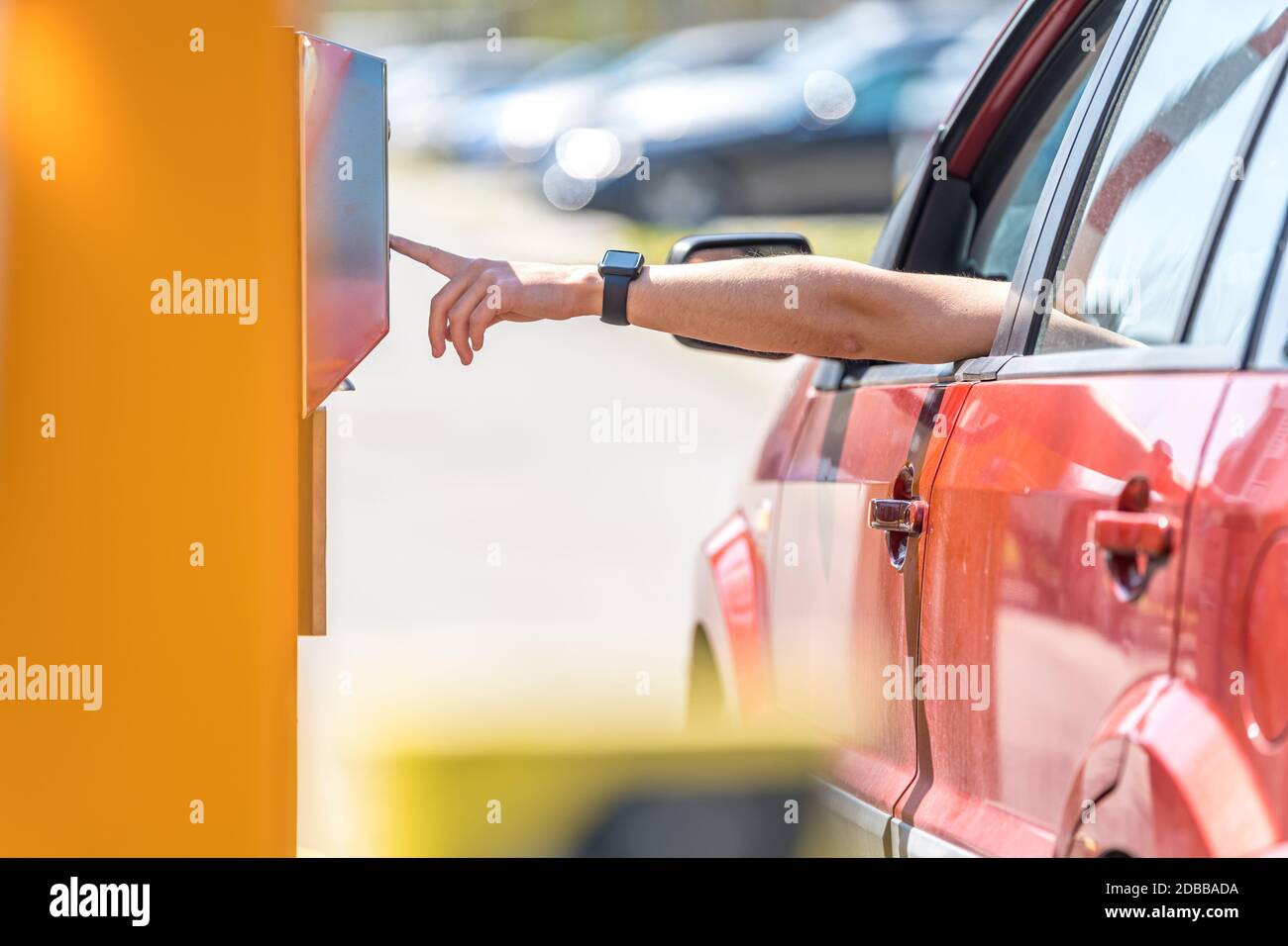 man push buttons parking meter at the entrance to the toll parking ...