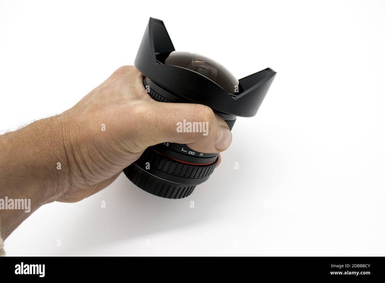 Hand holds black fisheye lens on white background Stock Photo - Alamy