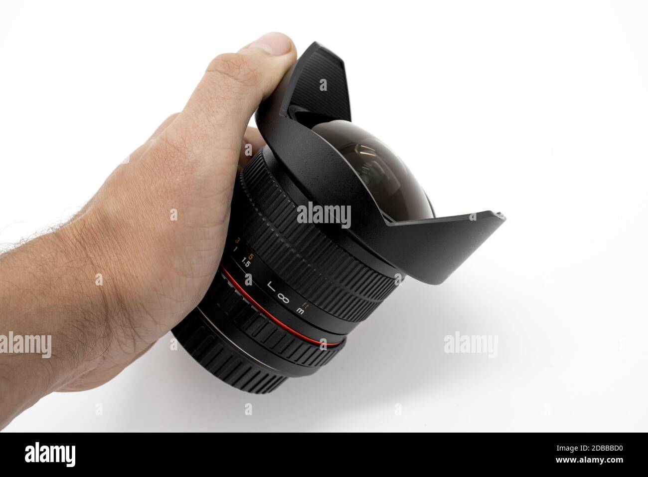 Hand holds black fisheye lens on white background Stock Photo - Alamy