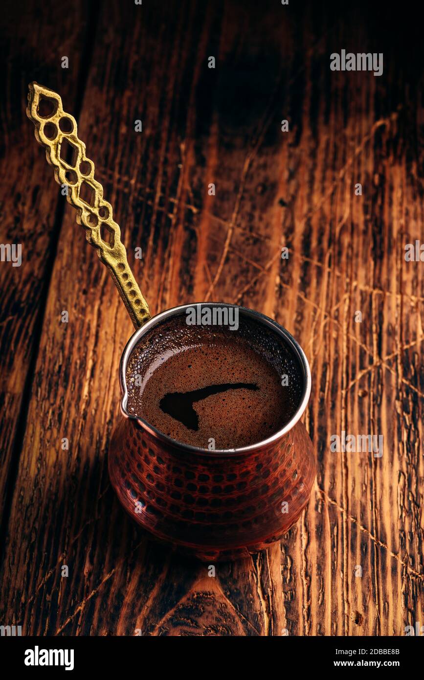 Turkish coffee. Brewed coffee in copper cezve on wooden surface Stock ...