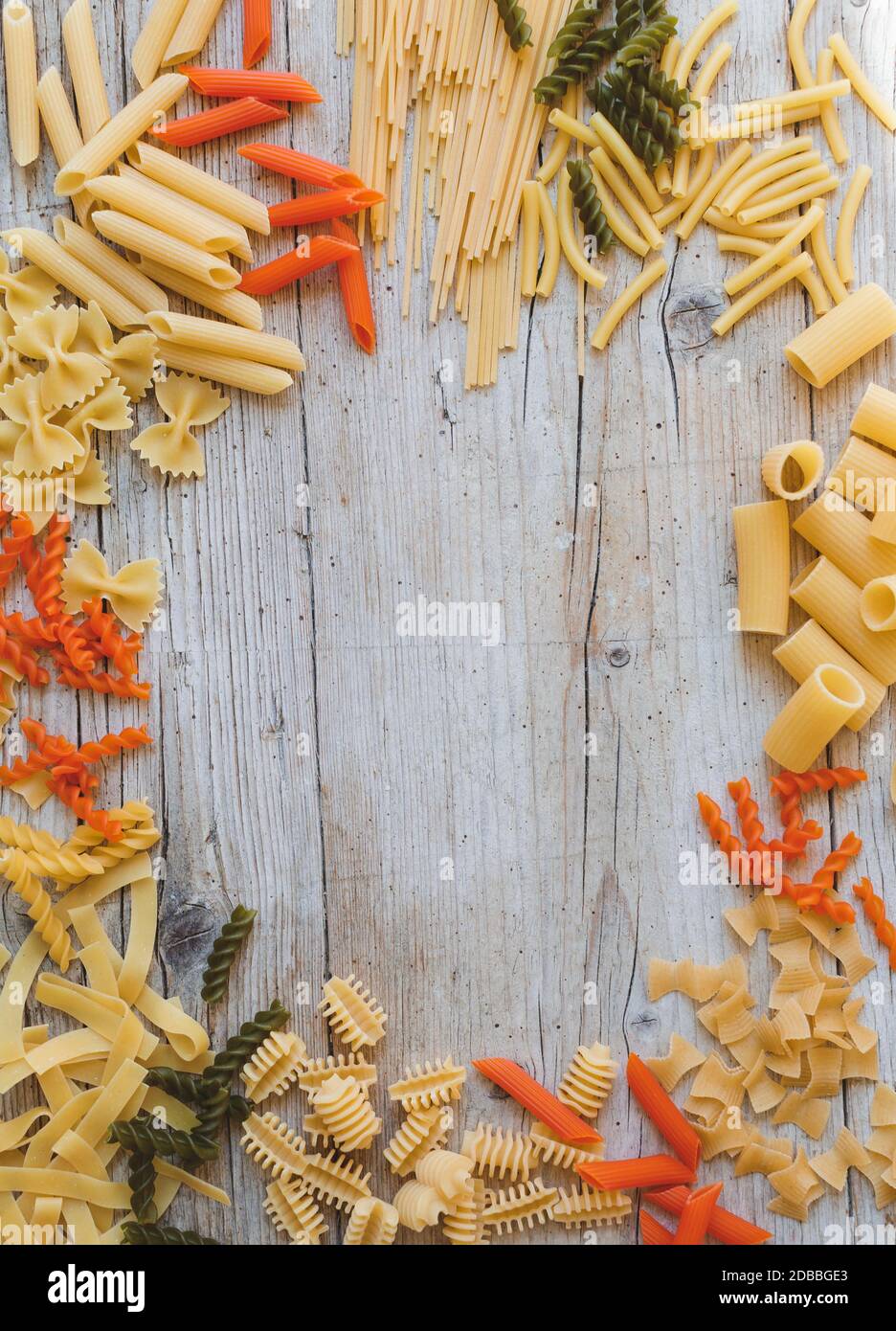 colourful mix of different noodles on wooden background photographed ...