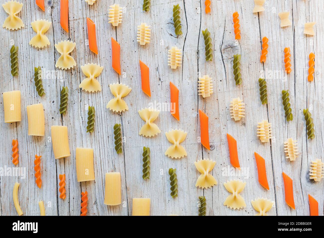 colourful mix of different noodles on wooden background photographed ...