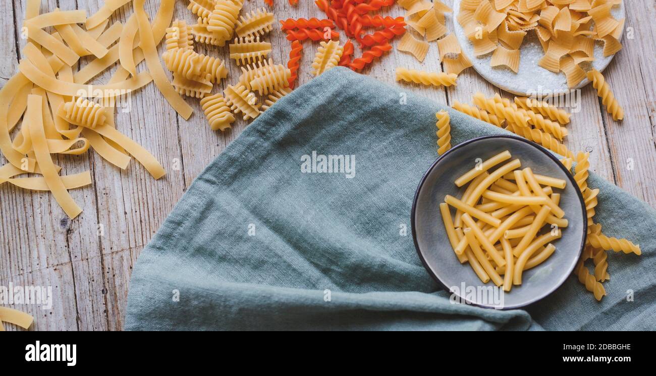 colourful mix of different noodles on wooden background photographed ...