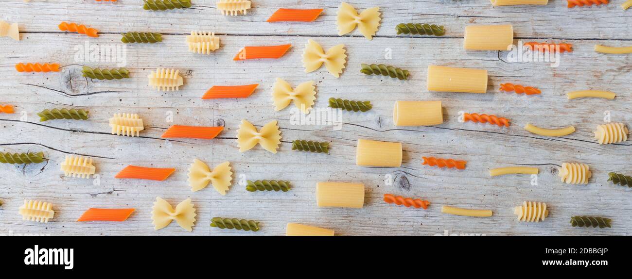 colourful mix of different noodles on wooden background photographed ...