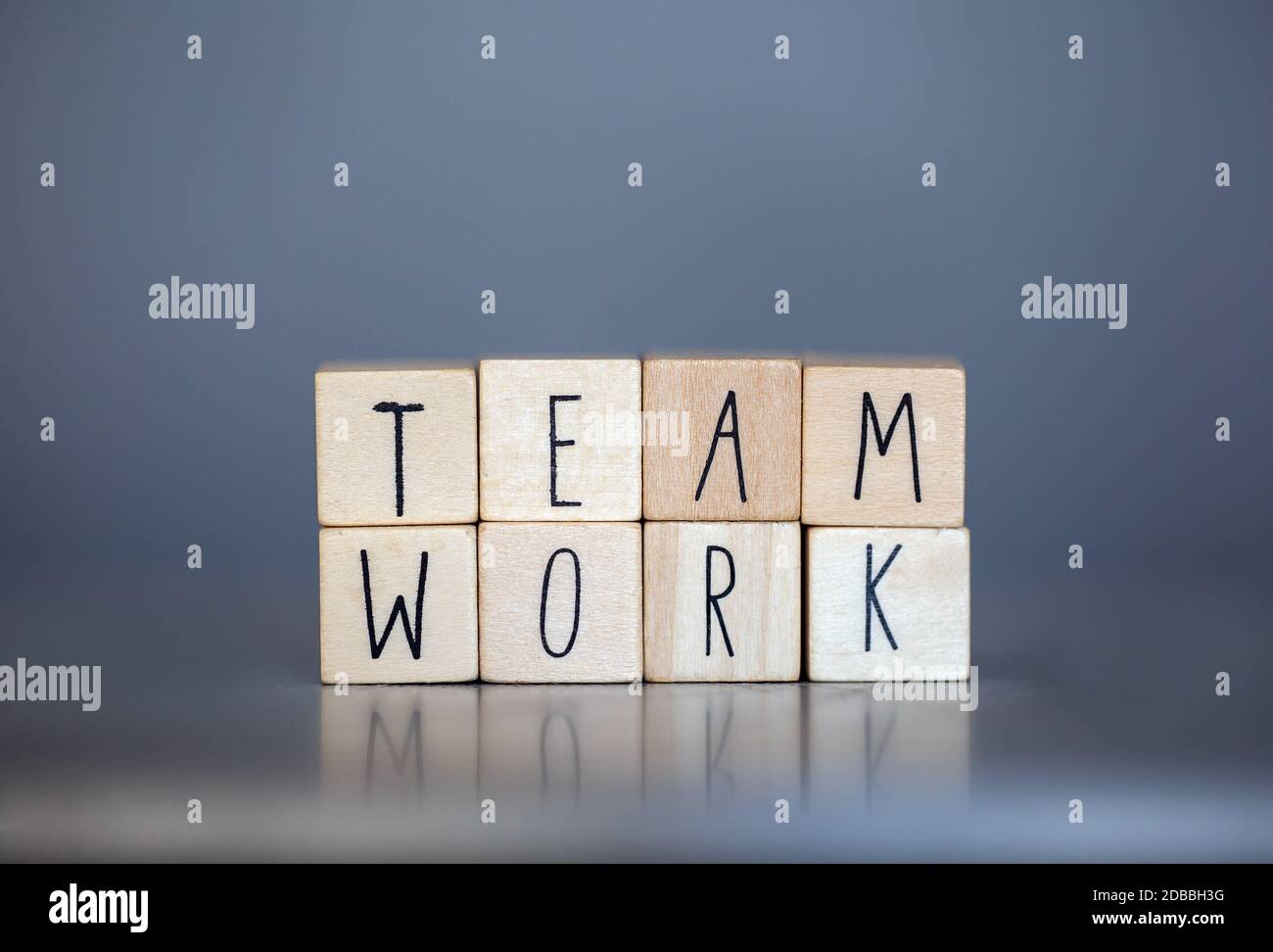 Wooden cubes with the words Team Work for business concept on grey blue ...