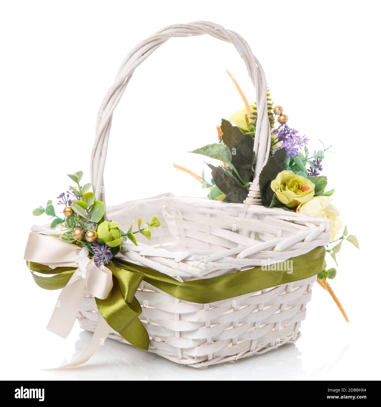 White wicker basket with floral decor and ribbons on white background ...