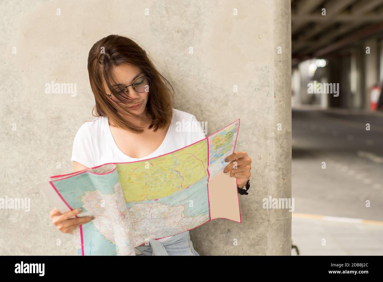 Asian woman holding a map for planning travel Stock Photo - Alamy