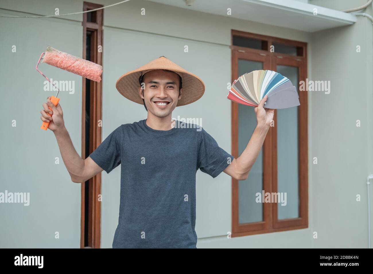 Painters wear caps with raise hands holding paint rollers and sample ...