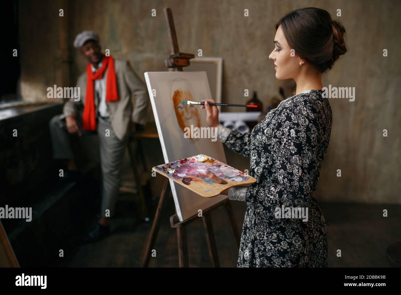 Female portrait painter and male model in art studio. Artist standing ...