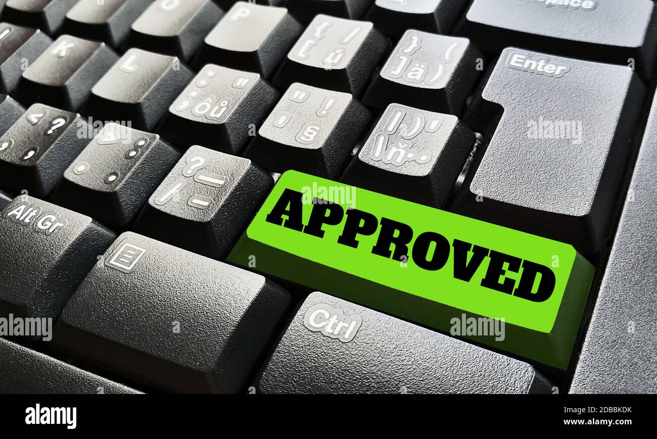 Black keyboard with one green key labeled by approved sign Stock Photo ...