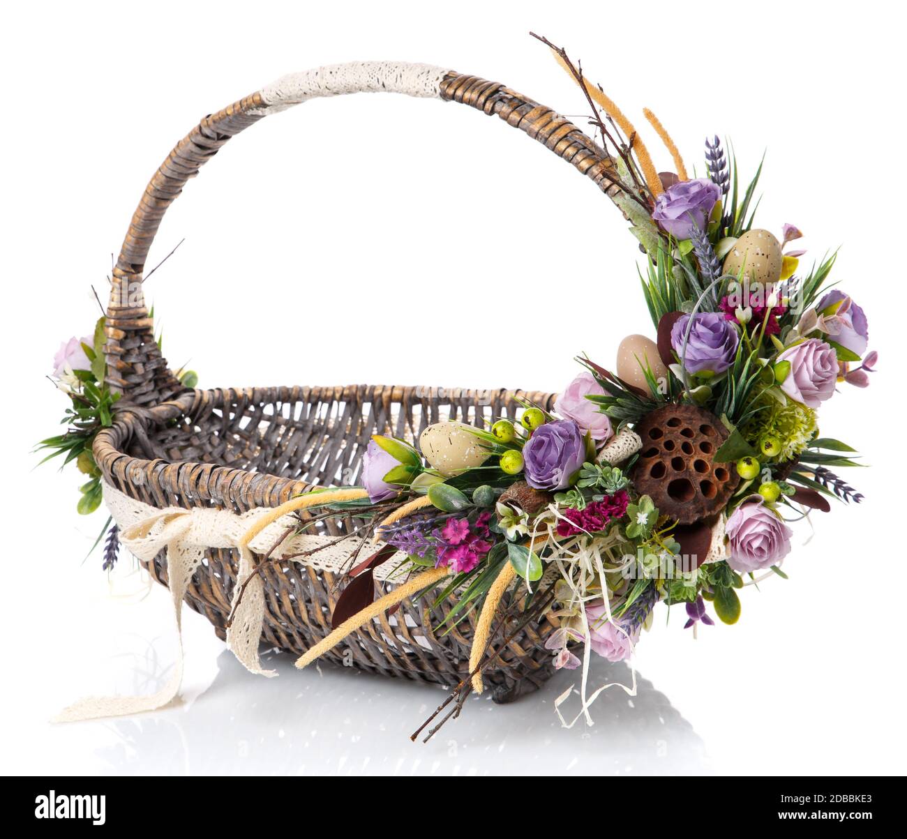 Brown wicker basket with original handle. Decor with flowers, eggs and ...