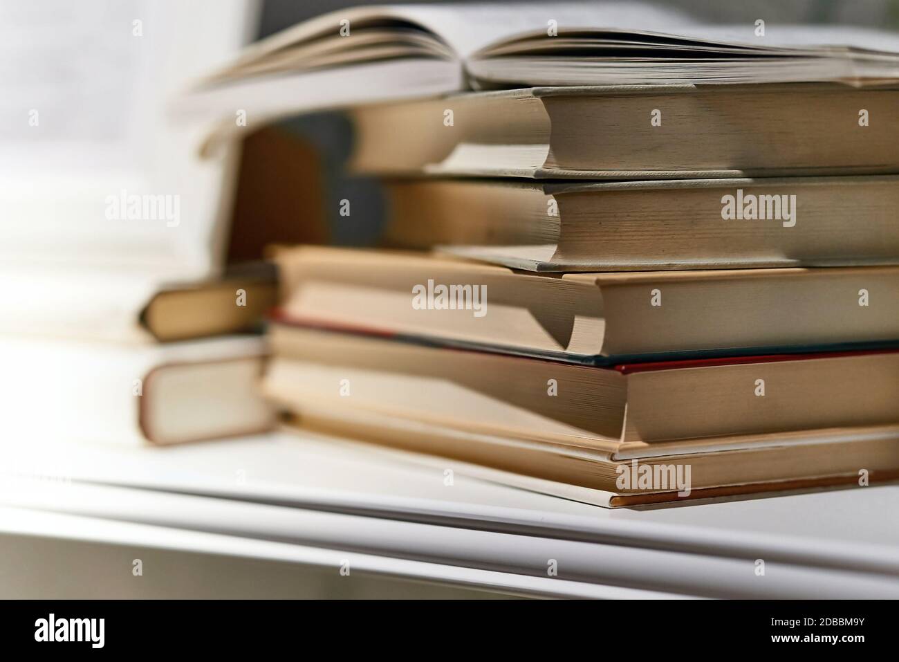 Book shelf with books in piles and rows Stock Photo - Alamy