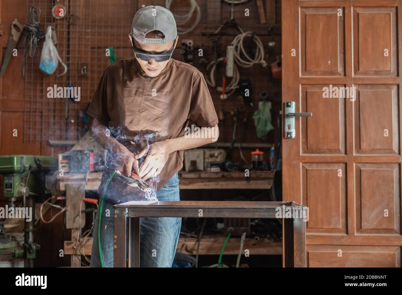 View from the front of A welder wearing black welding glasses while ...