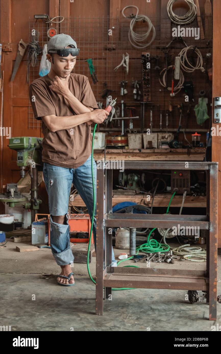 The welder thinks how to make a metal rack when holding an electric ...
