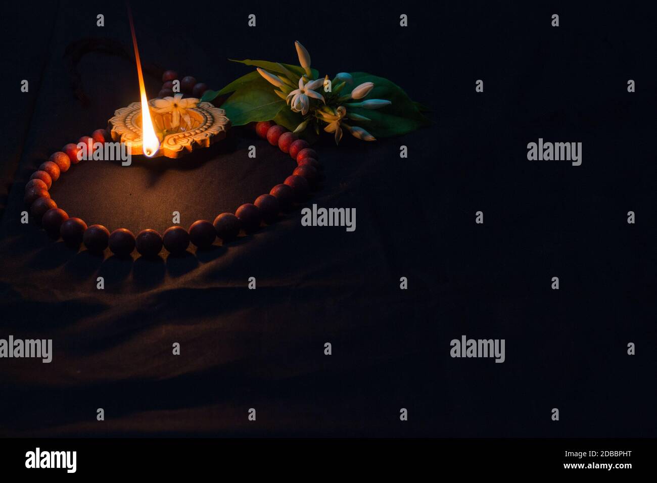 Indian traditional oil lamp made of clay with glowing flame, jasmine ...
