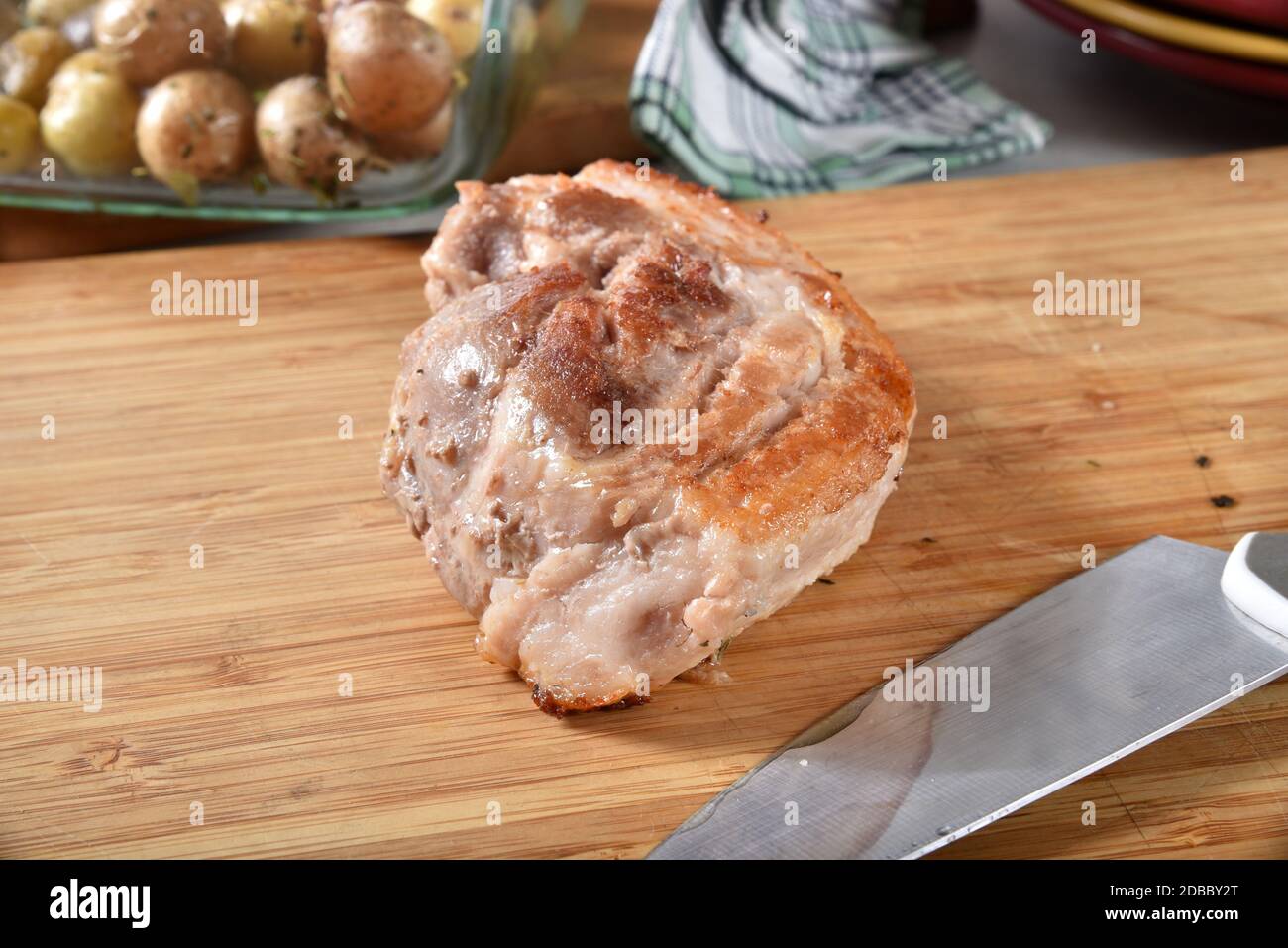 A slab of hot, juicy roasted pork belly on a cutting board Stock Photo ...