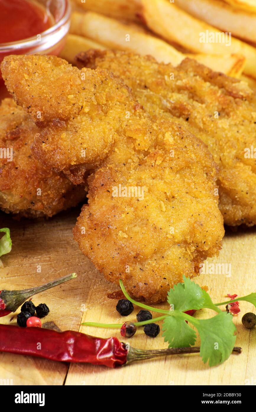 pieces of breaded chicken and fries Stock Photo - Alamy